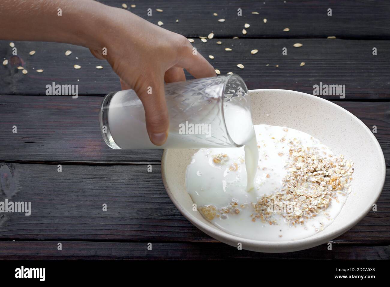 Oatmeal, cooking. Pouring milk into muesli Stock Photo - Alamy