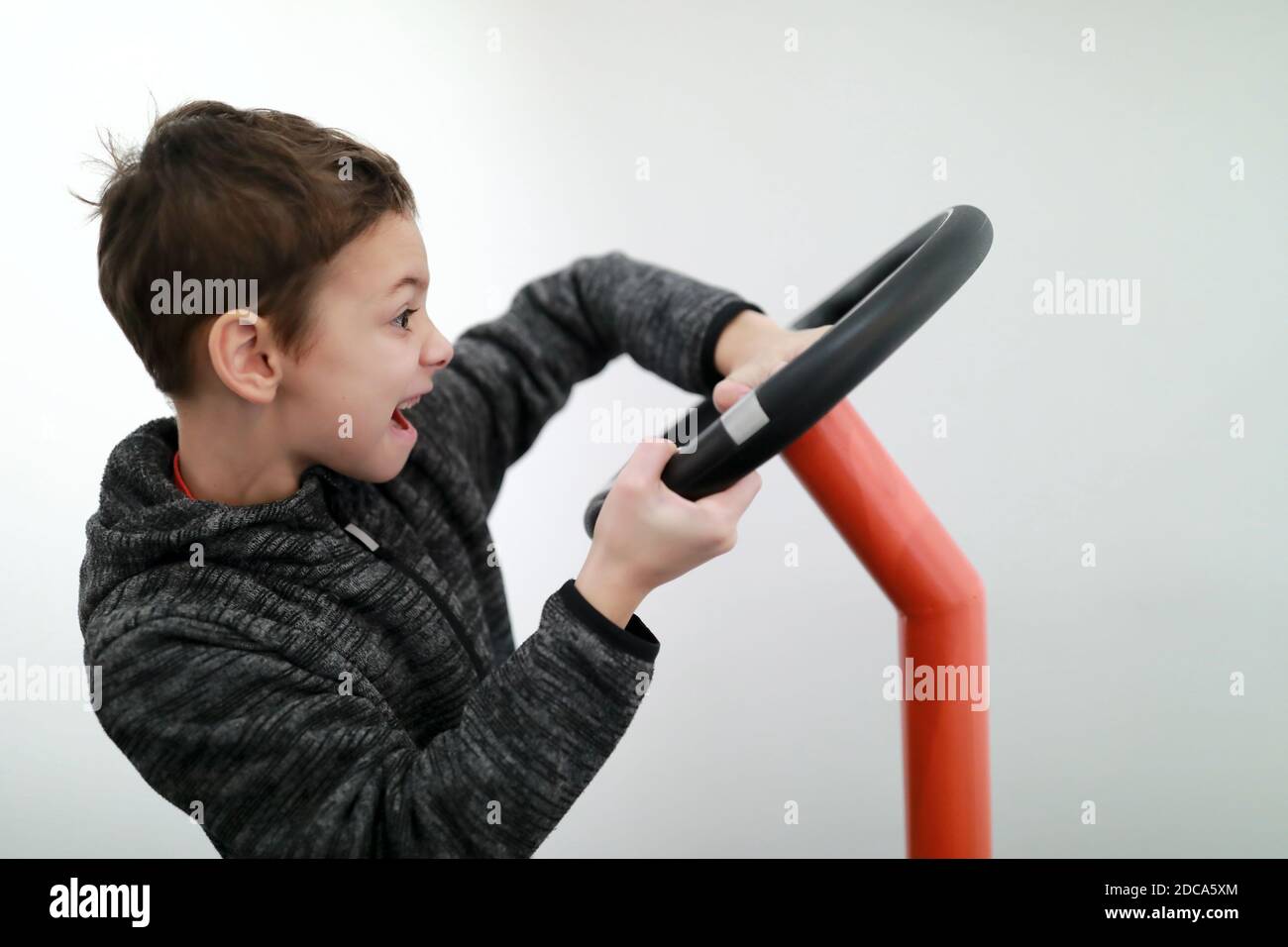 Child driving car simulator on wall background Stock Photo - Alamy