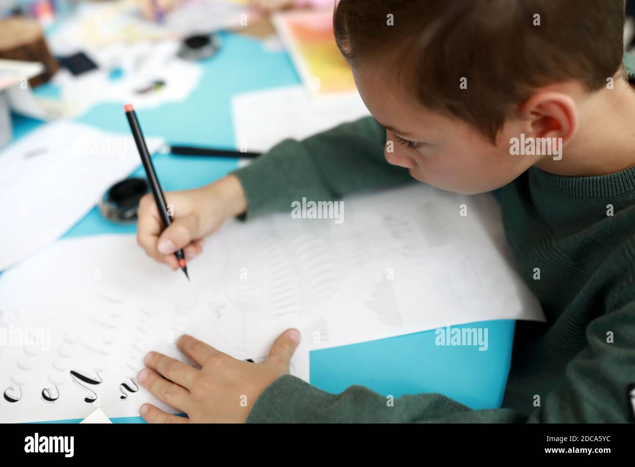 Portrait of child learning calligraphy at workshop Stock Photo - Alamy