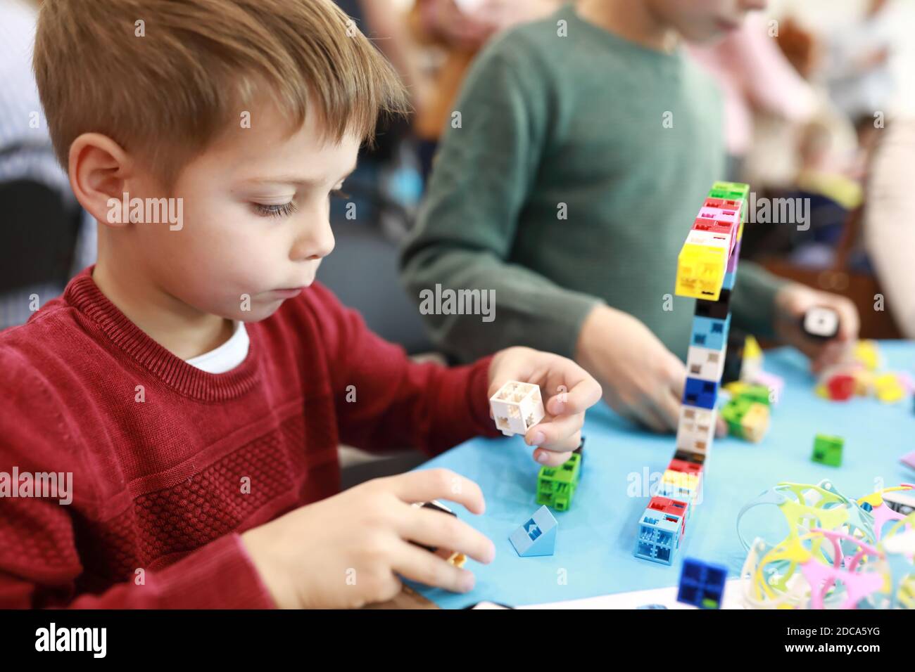 Boy playing plastic constructor at the table Stock Photo - Alamy