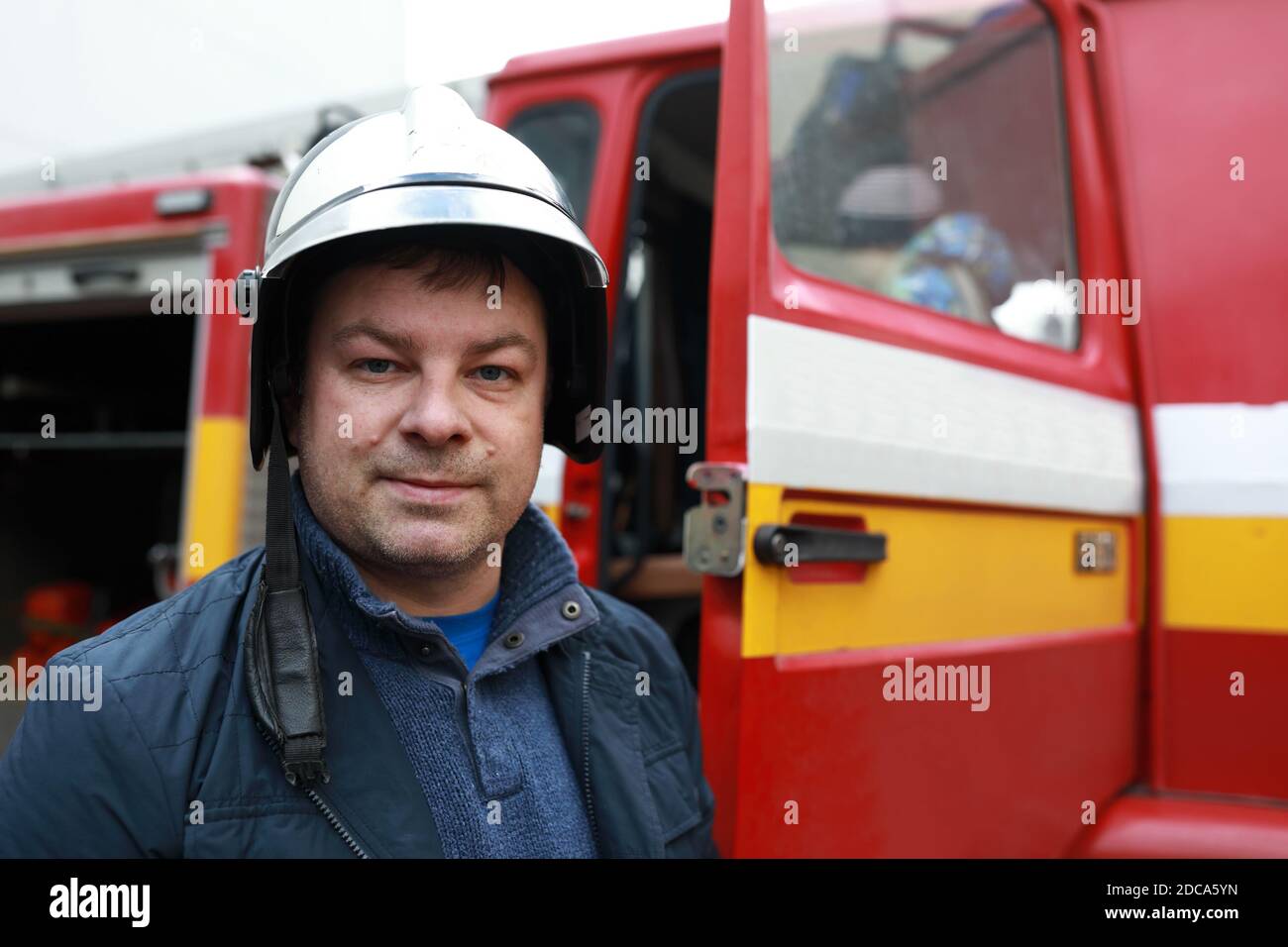 Portrait of fireman near a fire truck Stock Photo - Alamy