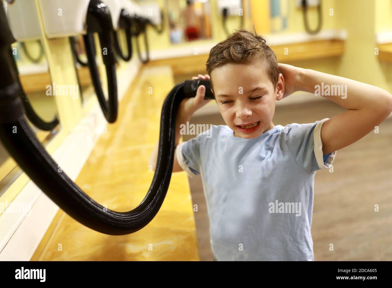 Child dries hair with hairdryer in gym locker room Stock Photo - Alamy