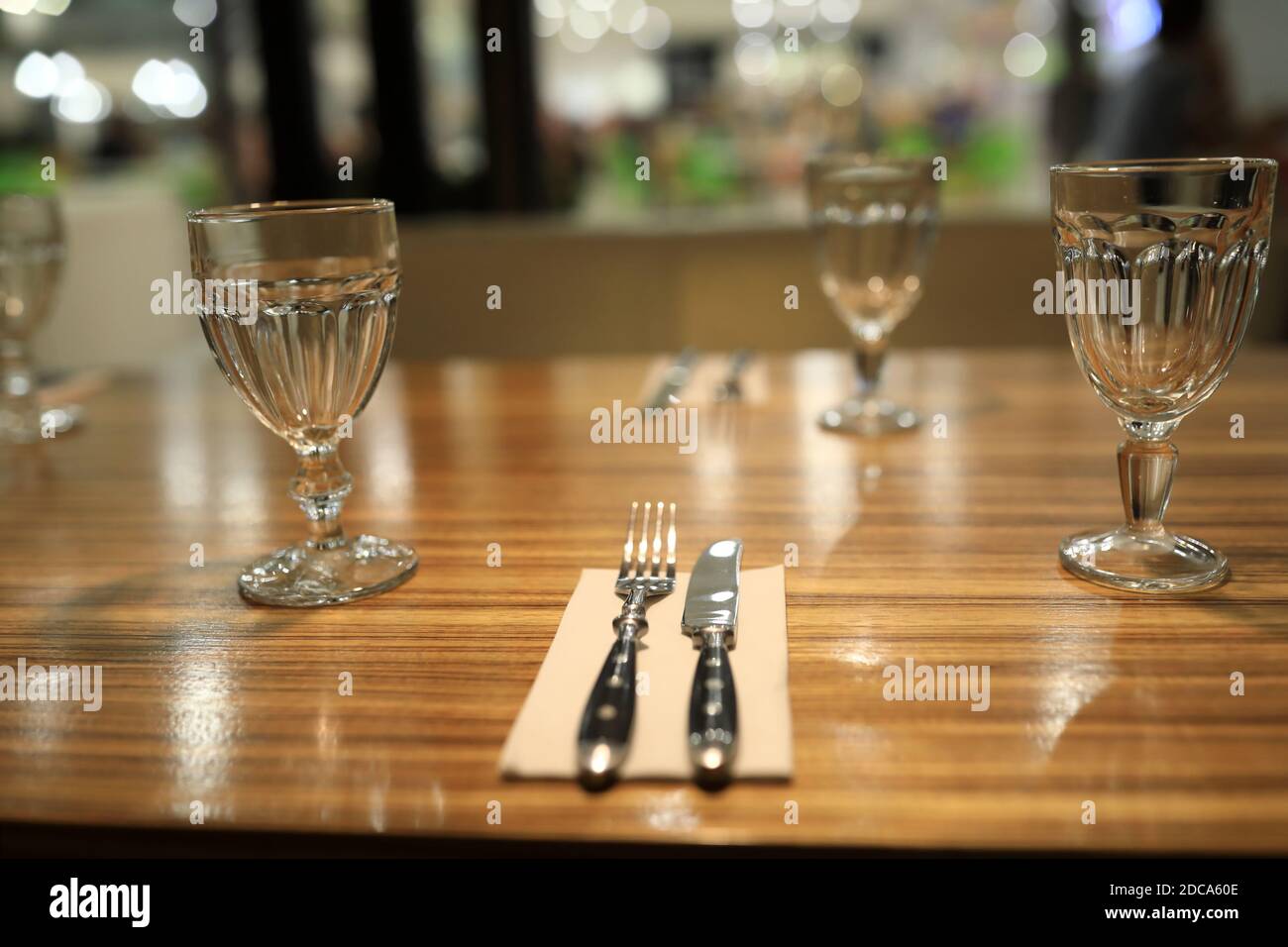 Wooden dining table with cutlery in restaurant Stock Photo - Alamy