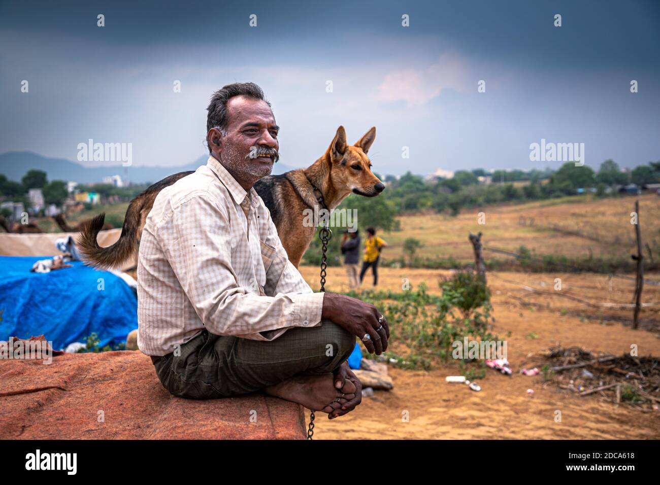 portrait of a man with its dog and behind is dramatic sky Stock Photo ...
