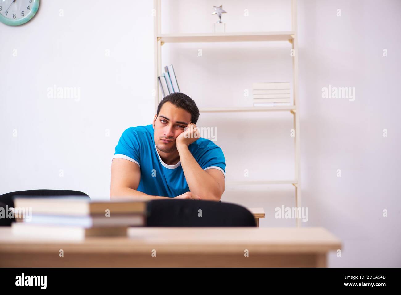 Exhausted student preparing for the exams in the classroom Stock Photo ...