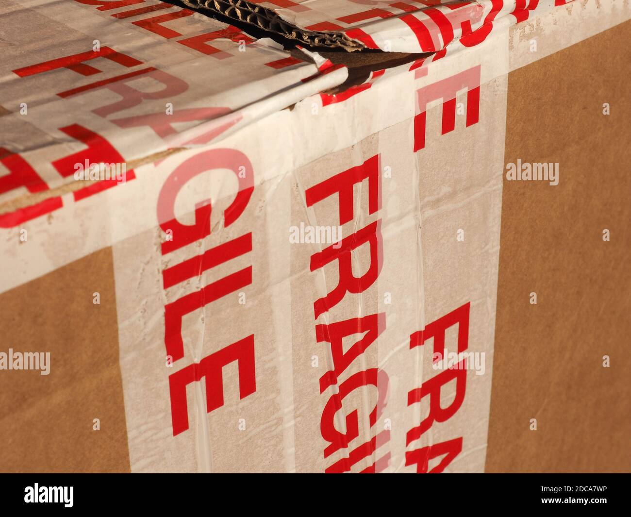 Fragile warning tape on corrugated cardboard box Stock Photo - Alamy