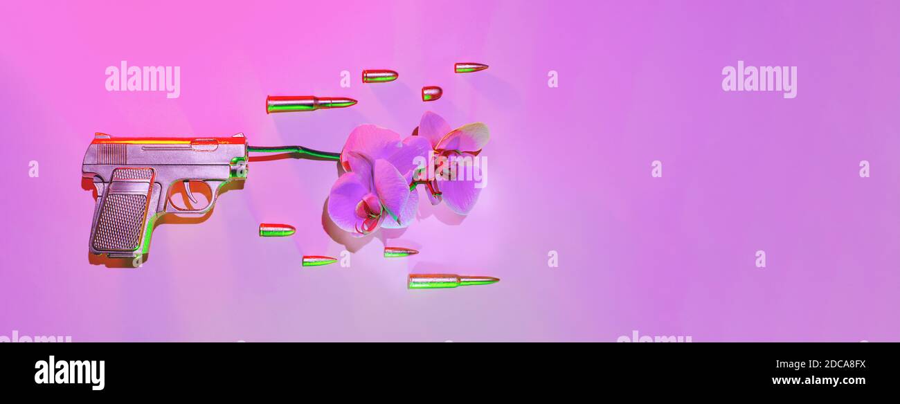 The golden gun shoots an orchid flower, next to fly bullets on a pink ...