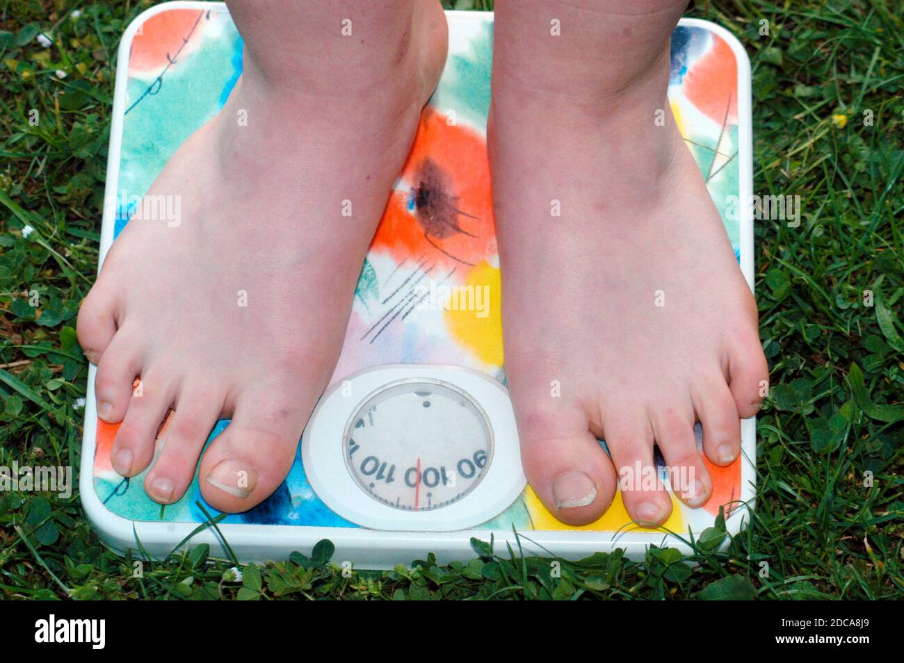 an overweight person standing on a weighing scale for weight ...