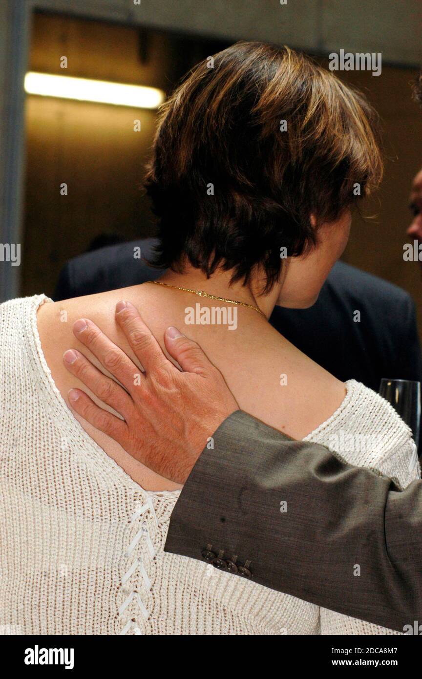 a couple at an event, he is touching her back Stock Photo - Alamy