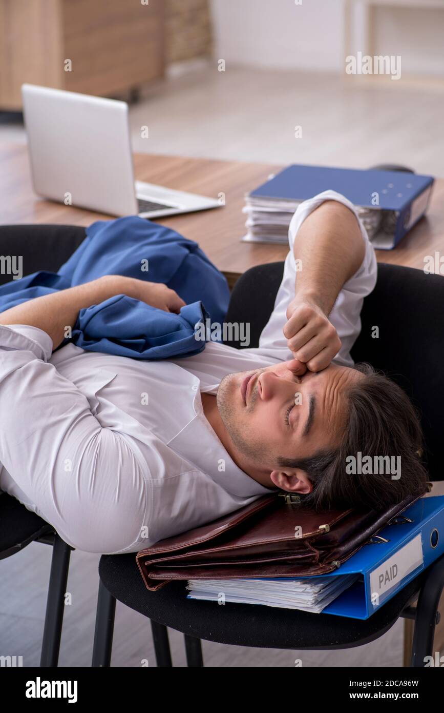 Young employee sleeping in the office on chairs Stock Photo - Alamy