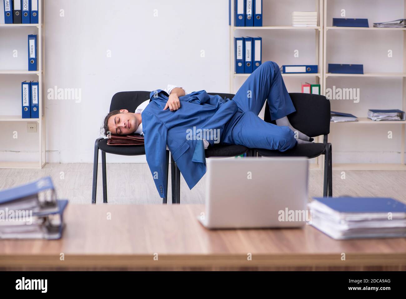 Young employee sleeping in the office on chairs Stock Photo - Alamy