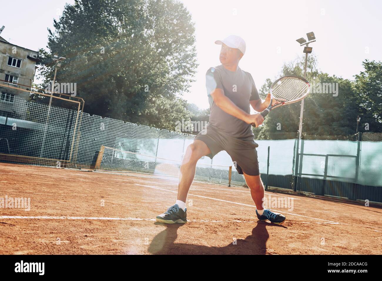 Middle-aged man playing tennis on outdoor tennis filed Stock Photo - Alamy