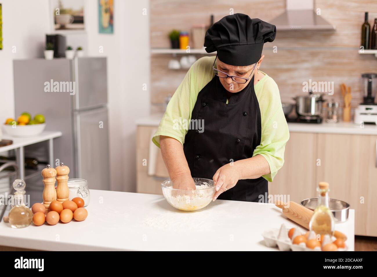 Chef in home kitchen preparing pasta dough following traditional recipe ...