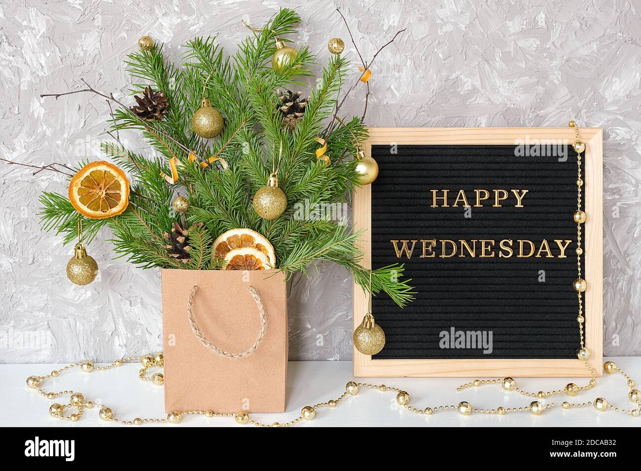 Happy Wednesday text on black letter board and festive bouquet of fir ...