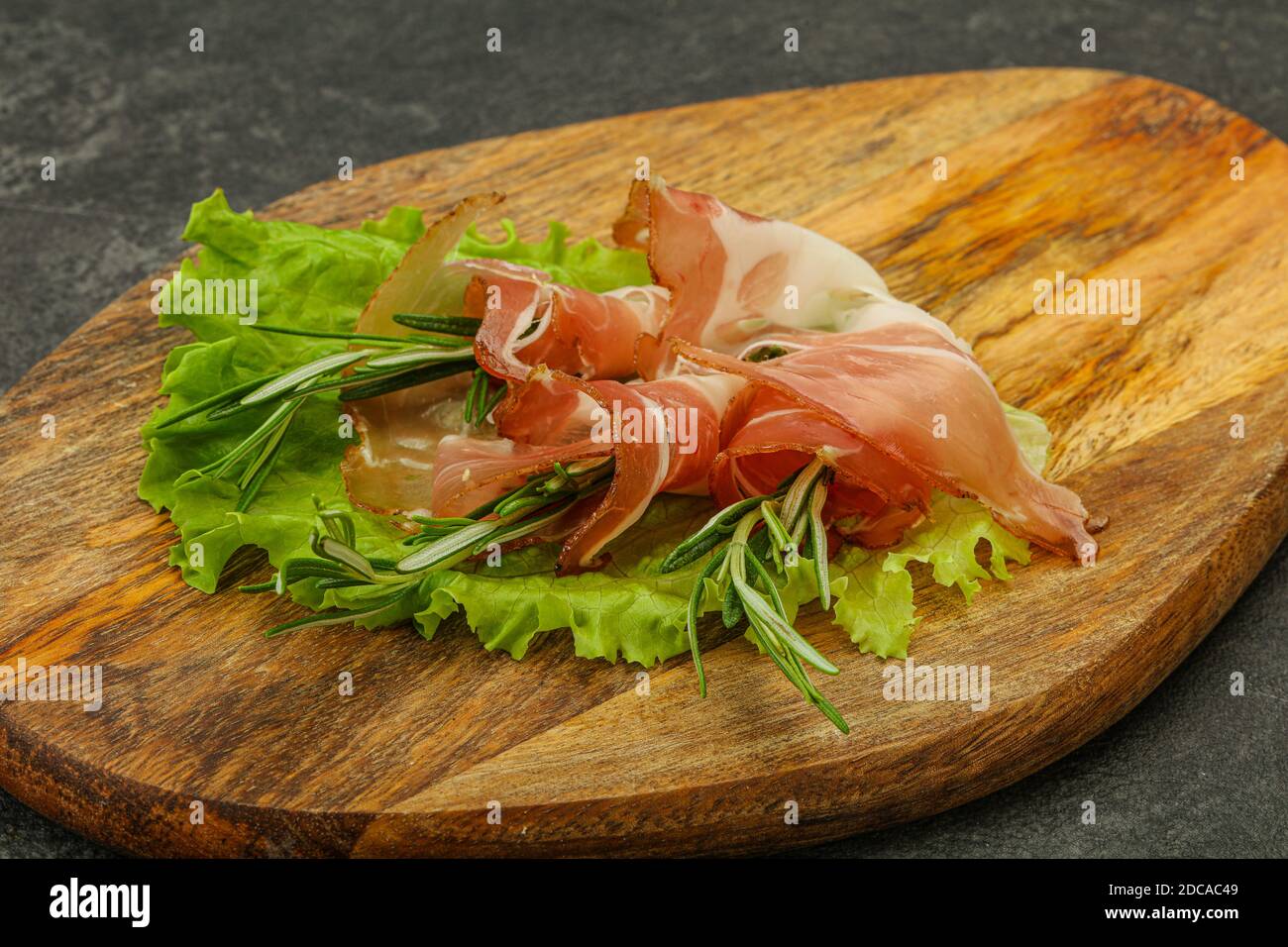 Sliced pork Jamon meat with rosemary Stock Photo - Alamy