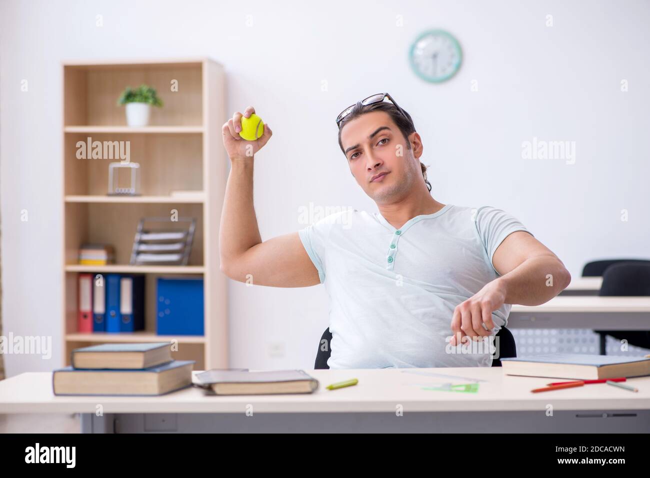 Male student throwing tennis ball during exam preparation in the ...