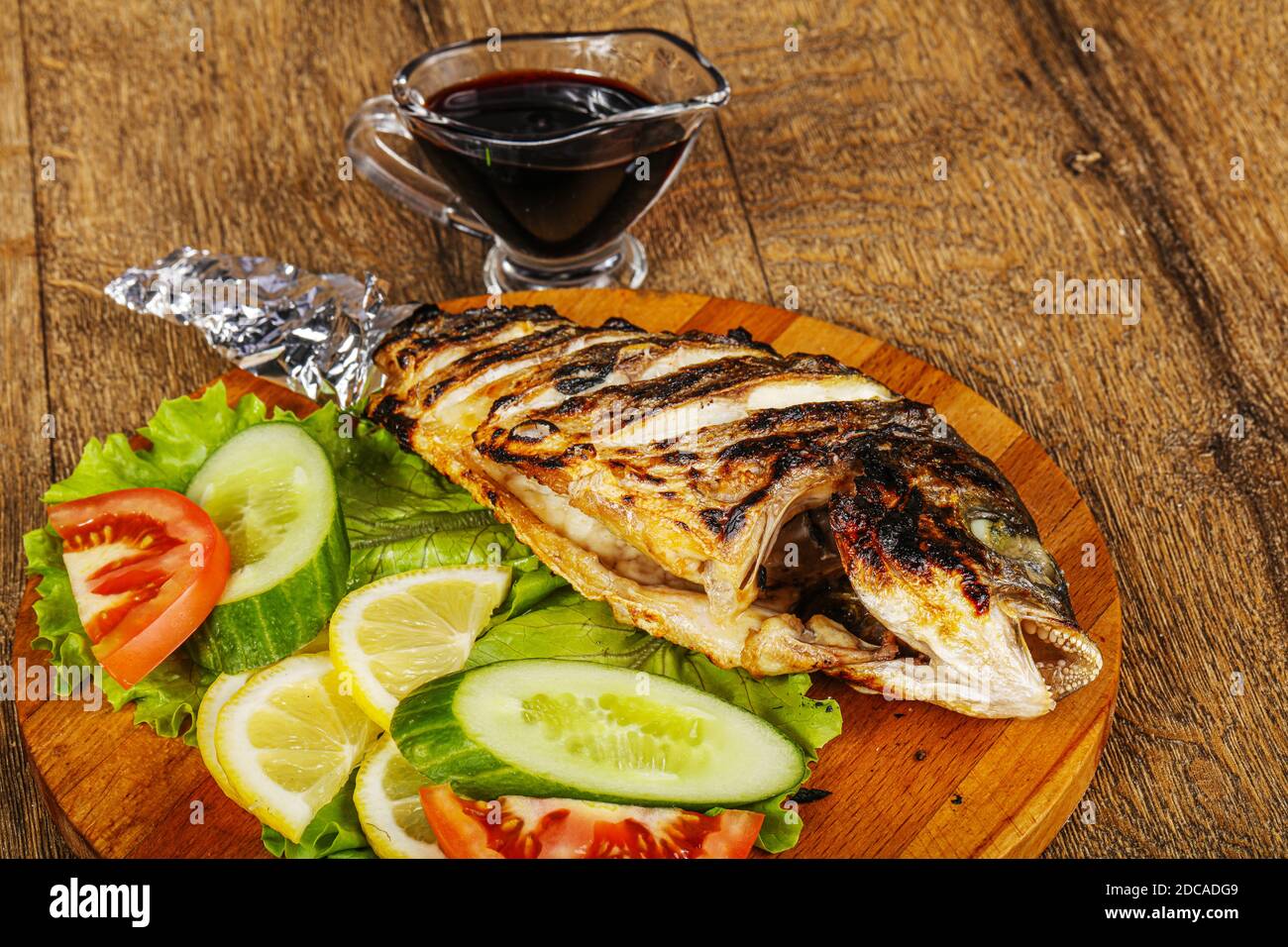 Grilled dorada fish with sauce and vegetables Stock Photo - Alamy