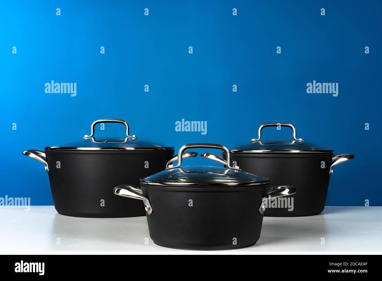 Set of black cookware against blue background Stock Photo - Alamy