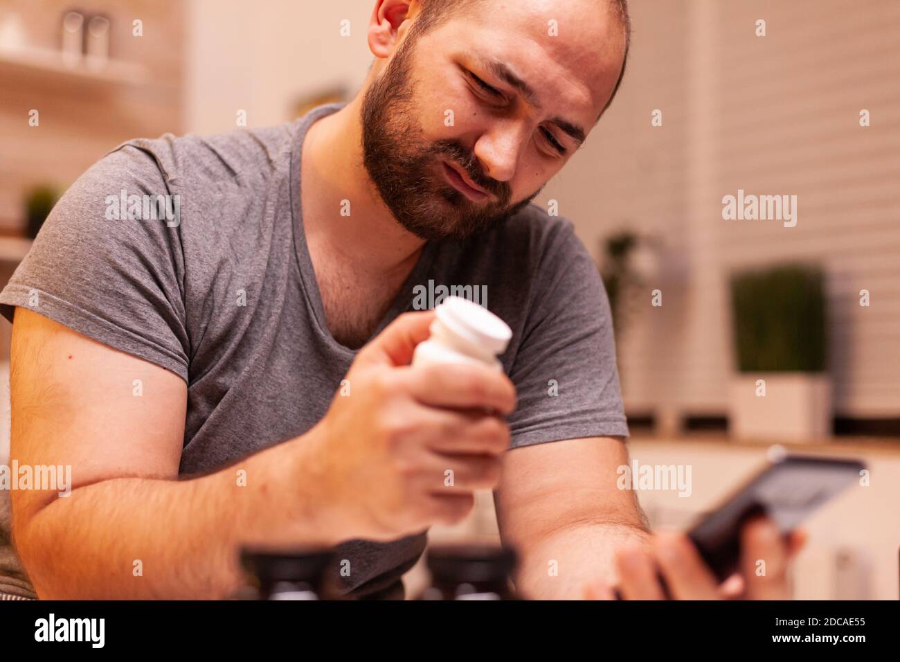 Unhealthy man treating symptom of depression with drugs from bottle in ...