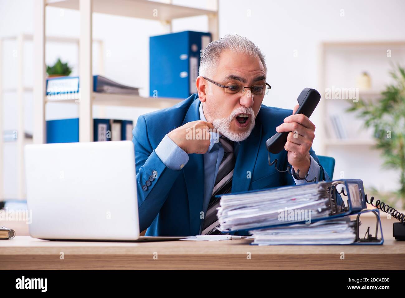 Senior male bookkeeper unhappy with excessive work at workplace Stock ...