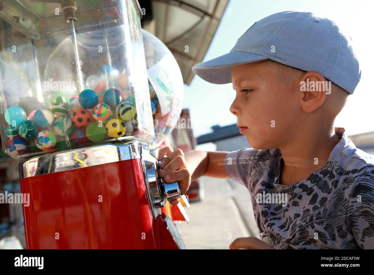 Child using vending toys on the street Stock Photo - Alamy