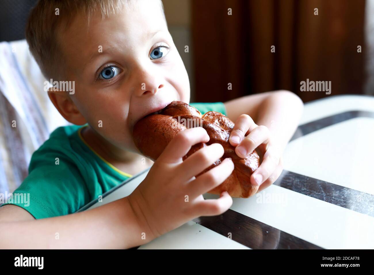 Child eating pie at table at home Stock Photo - Alamy