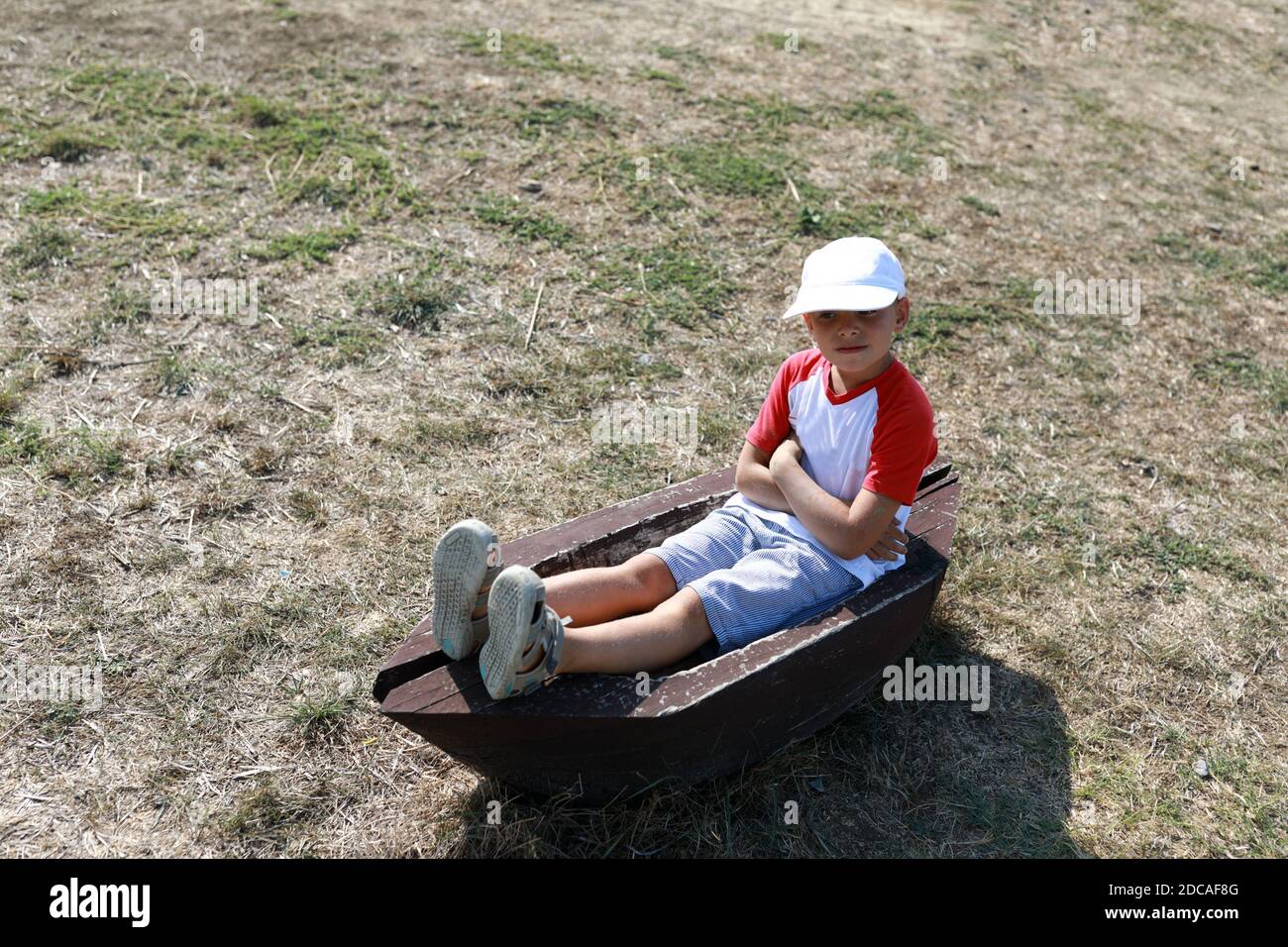 Child sitting in the trough in summer Stock Photo - Alamy