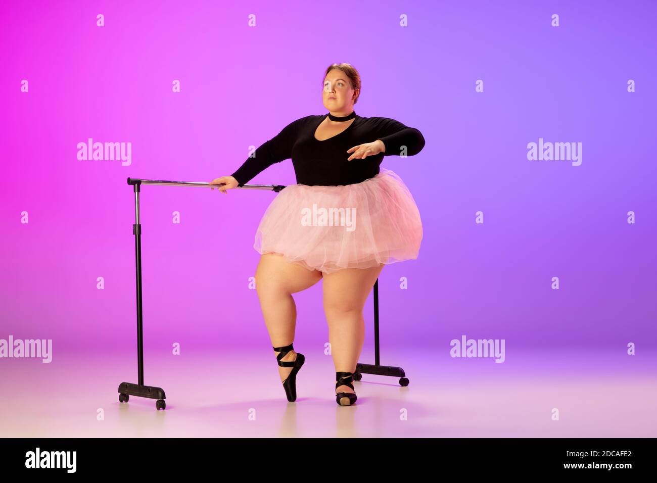 Beautiful caucasian plus size model practicing ballet dance on gradient ...