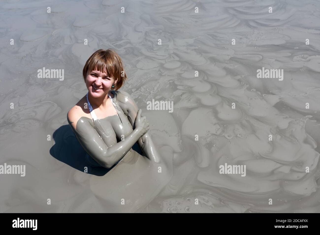 Portrait of woman resting in mud pool Stock Photo - Alamy