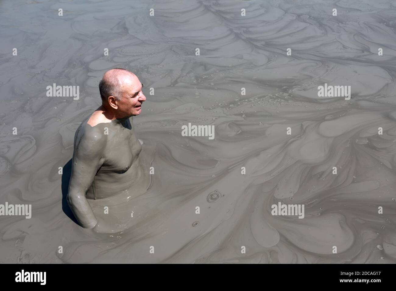 Portrait of senior man resting in mud pool Stock Photo - Alamy