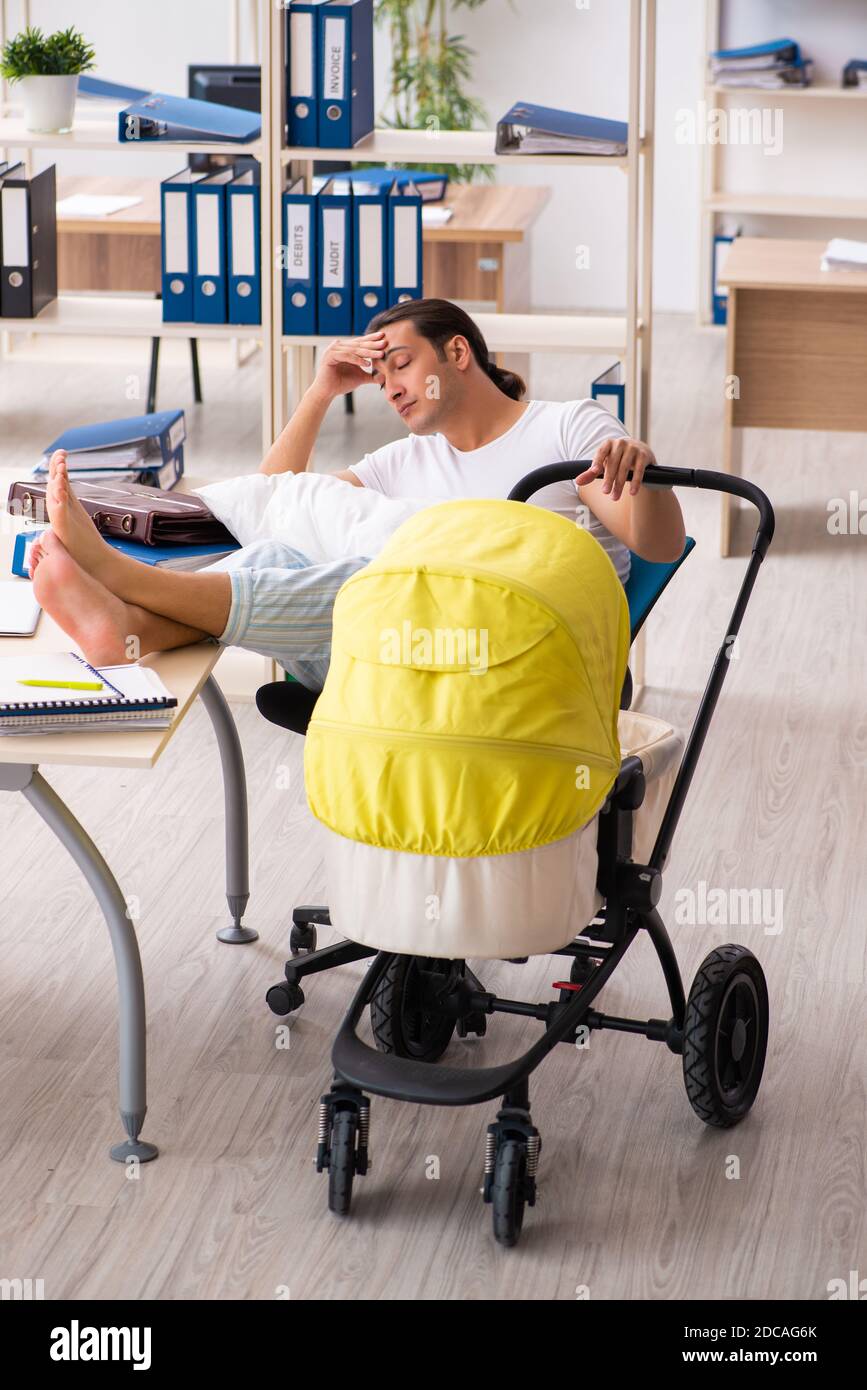 Young employee looking after newborn at workplace Stock Photo - Alamy