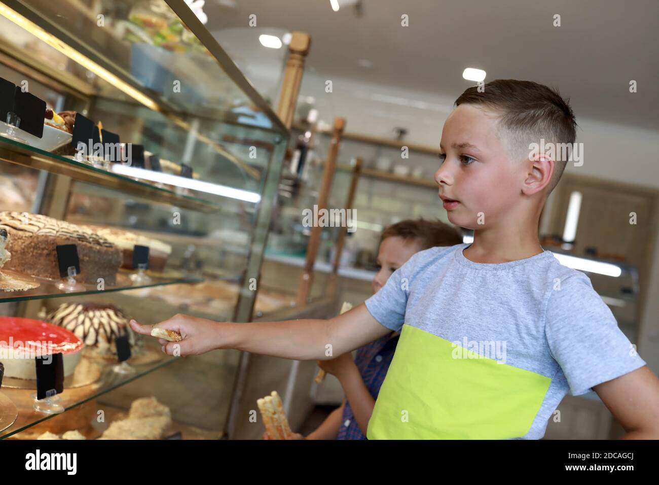 Boys choosing cake in a cafe window Stock Photo - Alamy