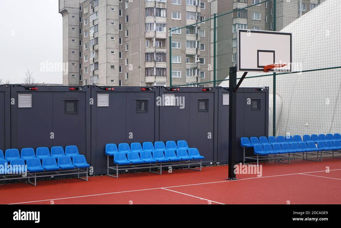 Blue plastic benches on metal frames near the new modern basketball ...