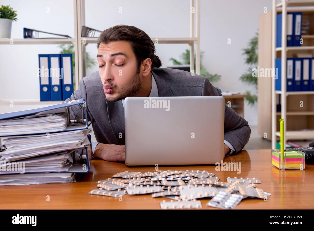 Male sick employee suffering at workplace Stock Photo - Alamy