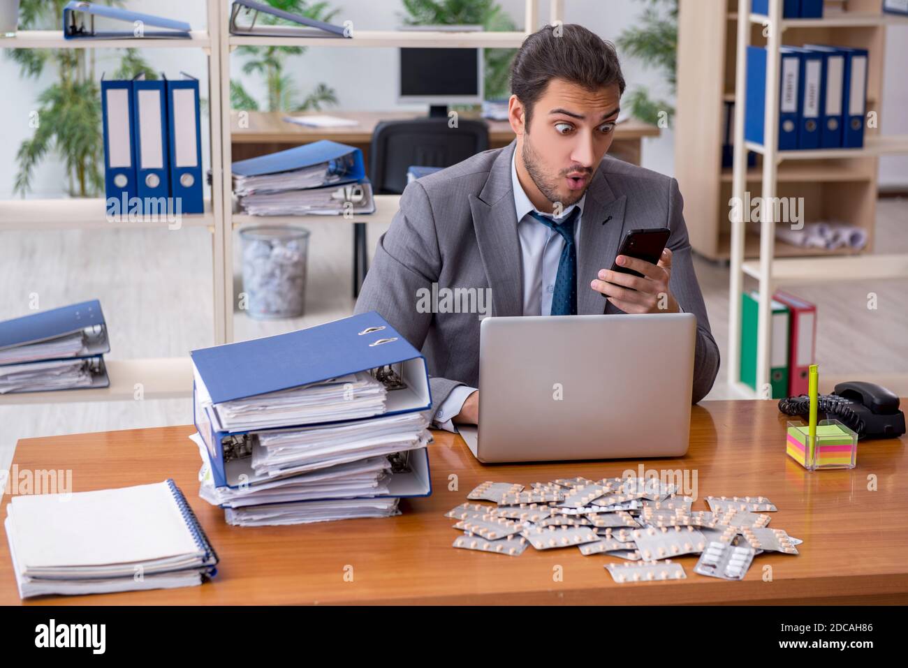 Male sick employee suffering at workplace Stock Photo - Alamy