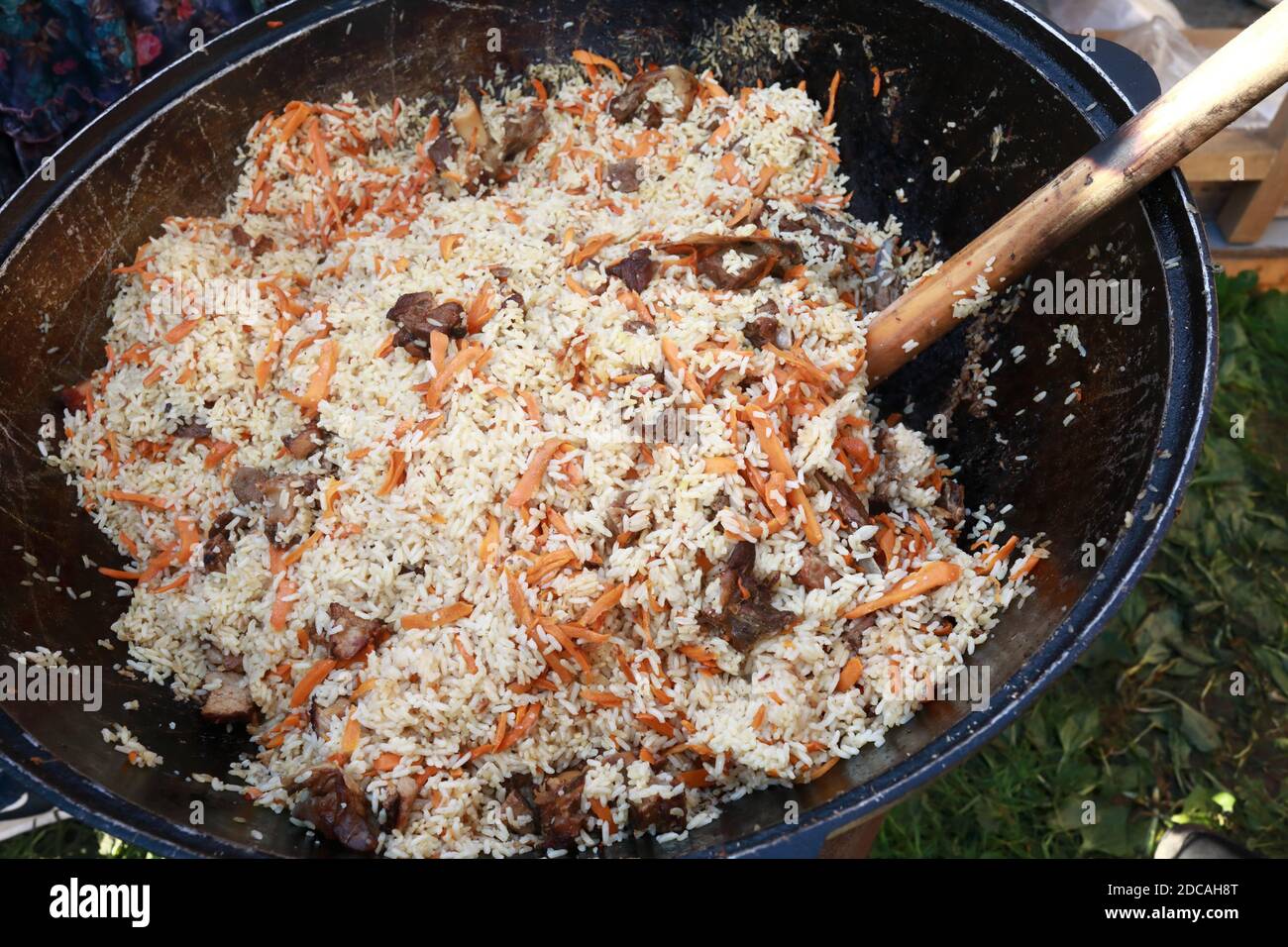 Meat pilaf cooked in cauldron on picnic Stock Photo - Alamy