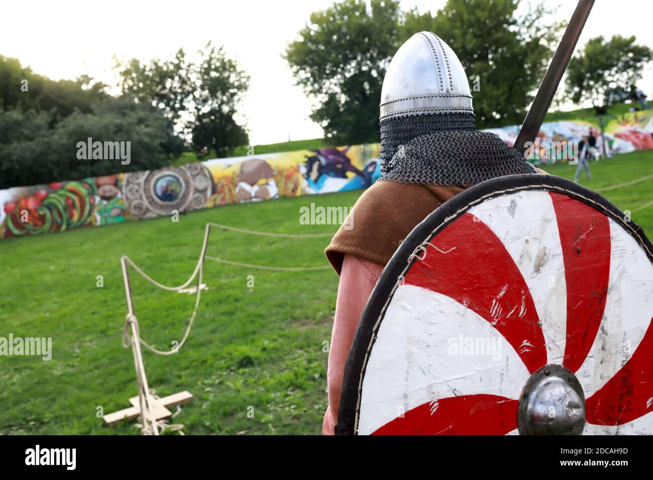 Knight with shield behind his back in park Stock Photo - Alamy
