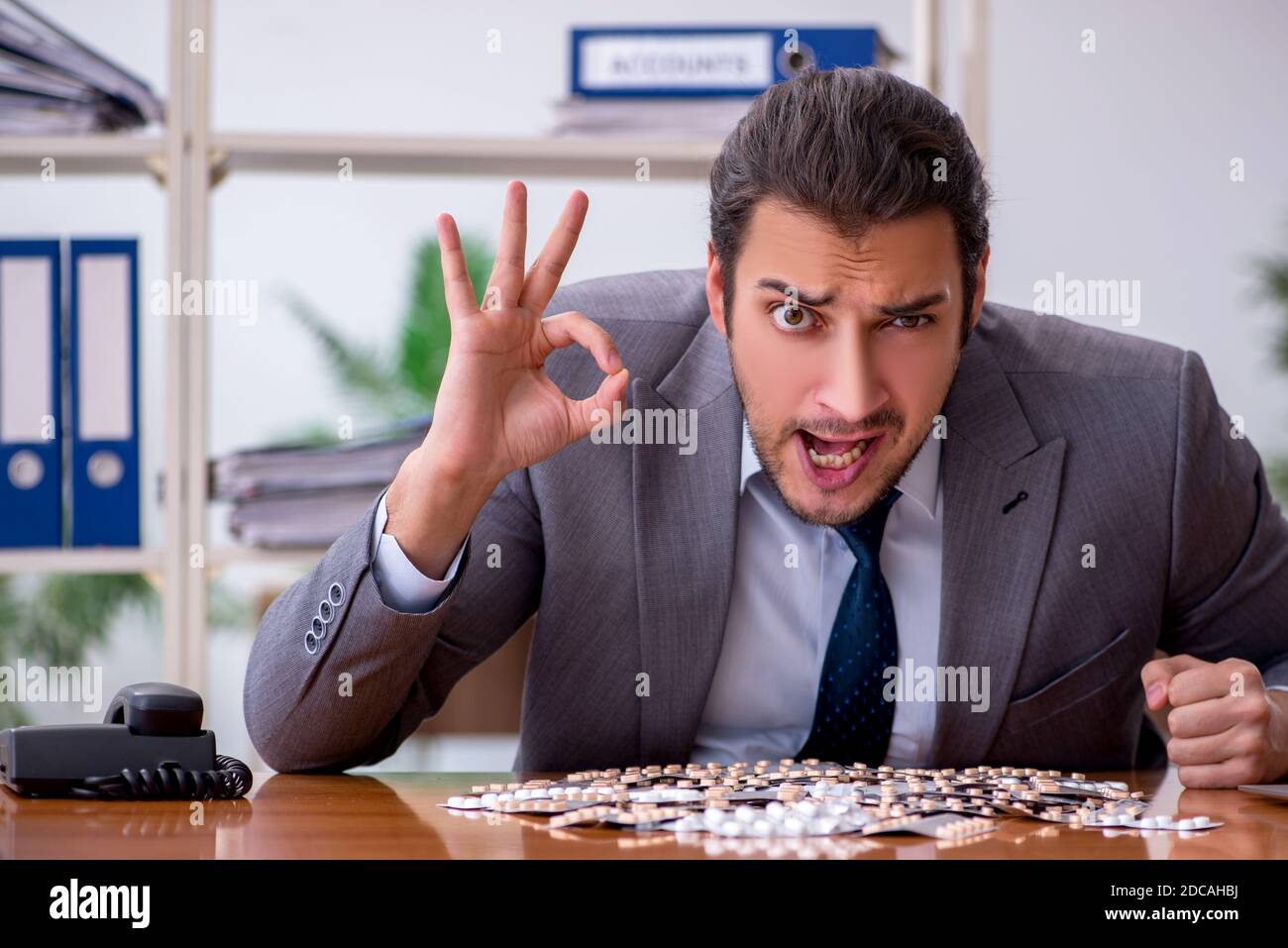 Male sick employee suffering at workplace Stock Photo - Alamy