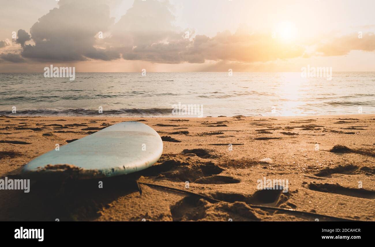 Surfboard on sand at summer beach with sunset light background Stock ...