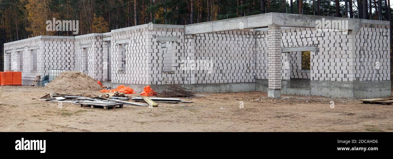 The building of unfinished rural houses in autumn forest. Panoramic ...