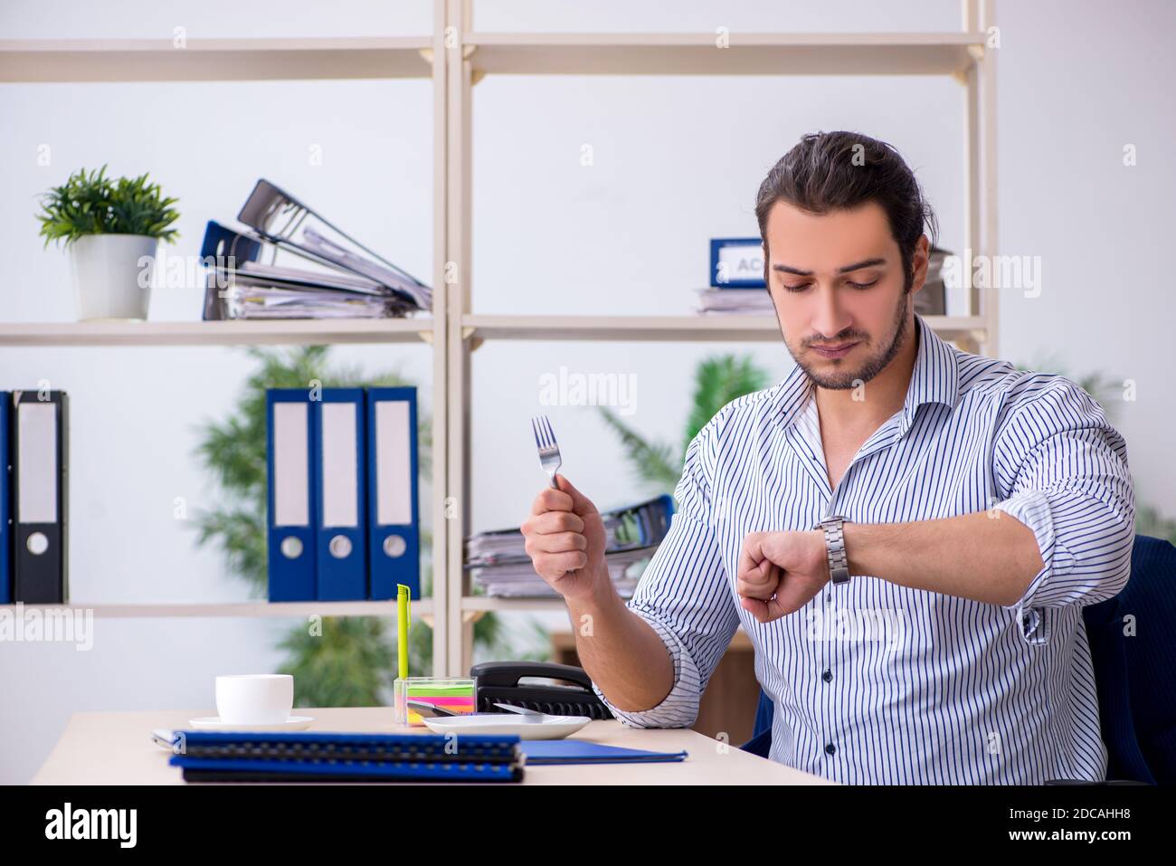 Hungry employee waiting for food in time management concept Stock Photo ...