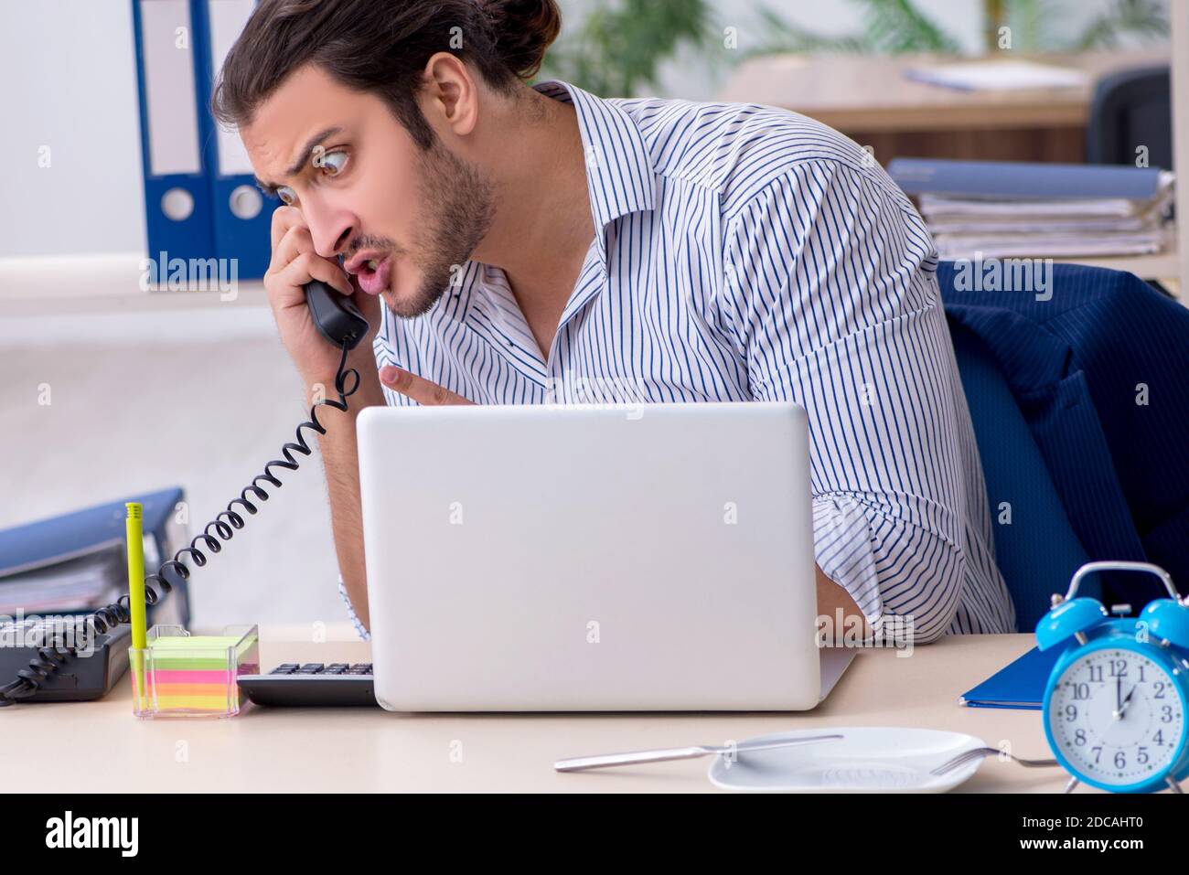 Hungry employee waiting for food in time management concept Stock Photo ...