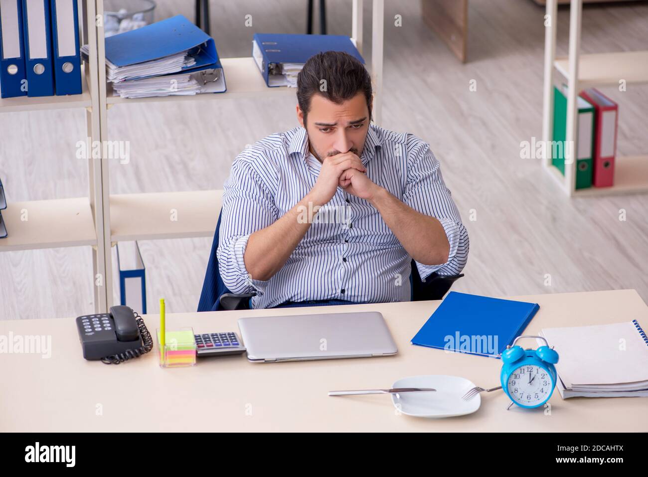 Hungry employee waiting for food in time management concept Stock Photo ...