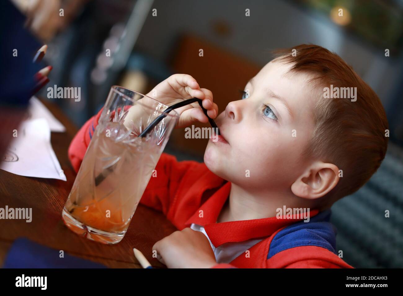 Boy is drinking lemonade in a restaurant Stock Photo - Alamy