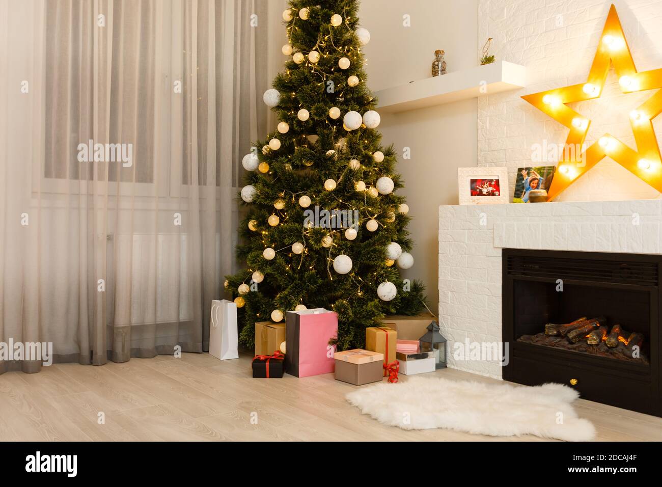 Christmas scene with tree gifts and fire in background Stock Photo - Alamy