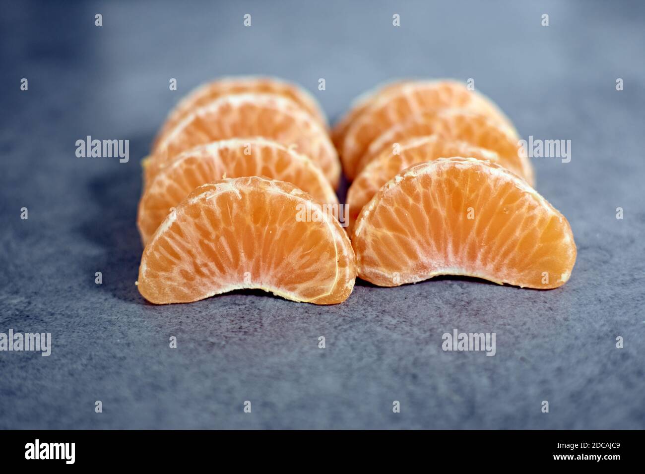 A high angle shot of tangerine pieces on a rough surface Stock Photo ...