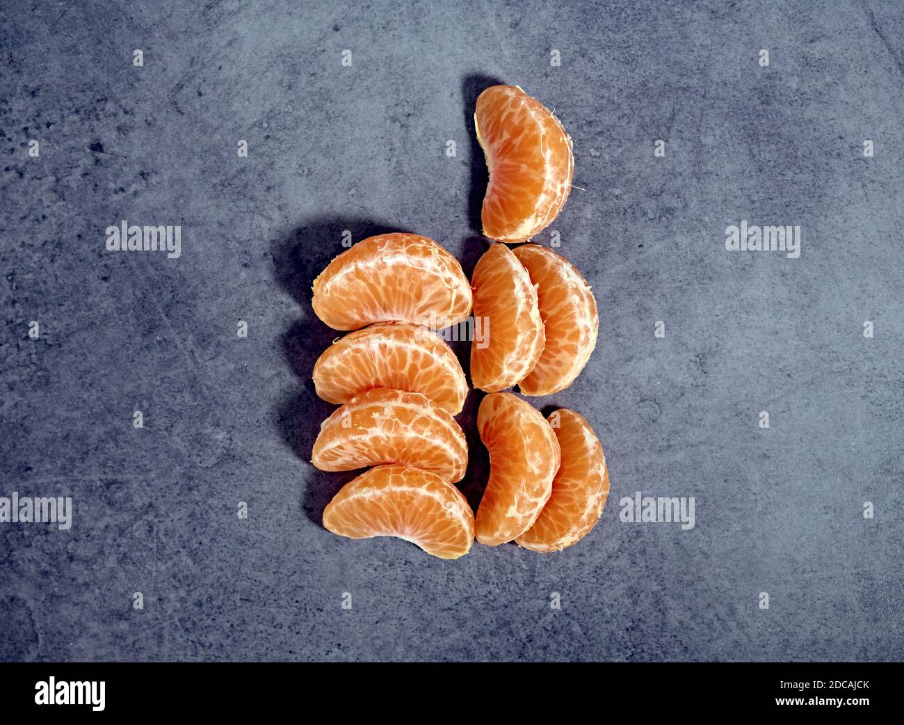A high angle shot of tangerine pieces on a rough surface Stock Photo ...