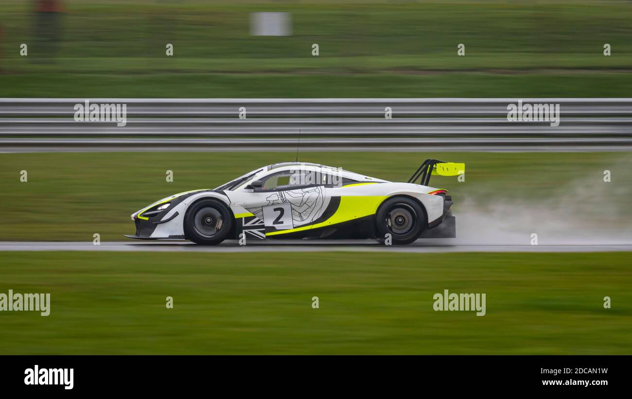 A panning shot of a racing car as it circuits a track Stock Photo - Alamy