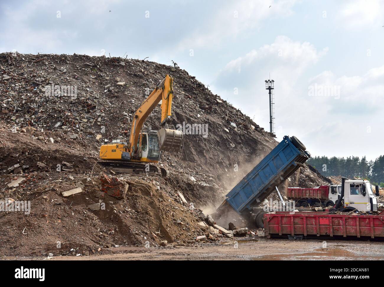 Excavator dig construction waste at landfill. Truck with metal tank and ...