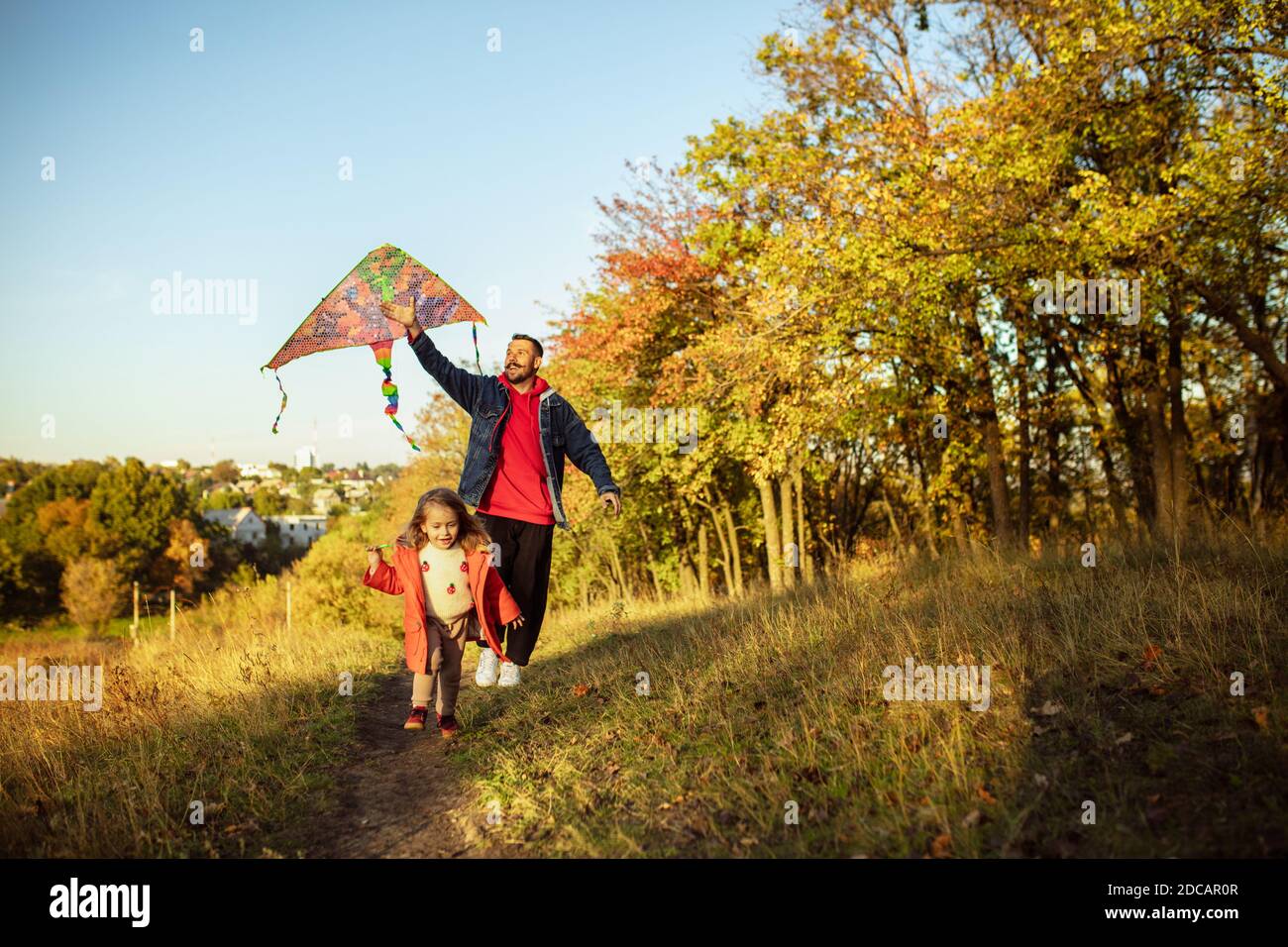 Flying kite. Happy father and little cute daughter walking down the ...